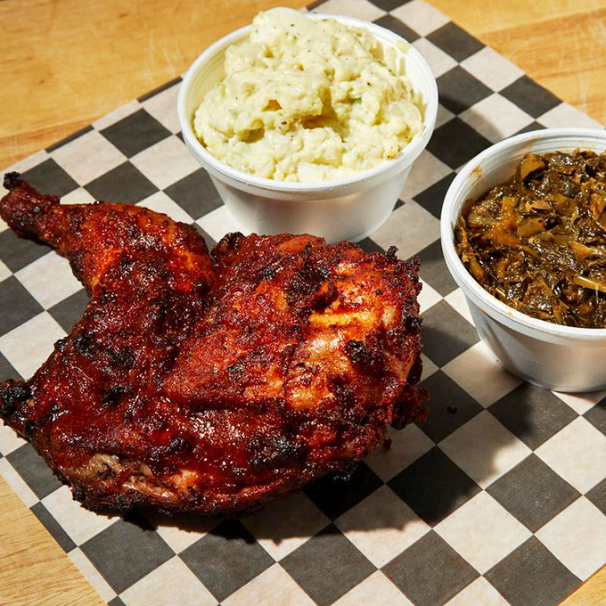 Smoke-kissed chicken with sides of creamy potato salad and collard greens. The kind of plate that makes you want to hug the pitmaster.