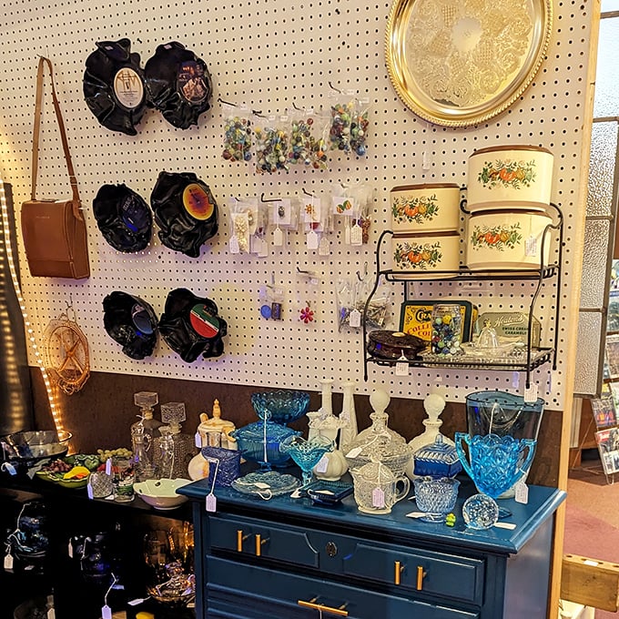 A symphony in blue glass plays across this display, where vintage records meet crystal stemware in that perfect antique mall harmony.