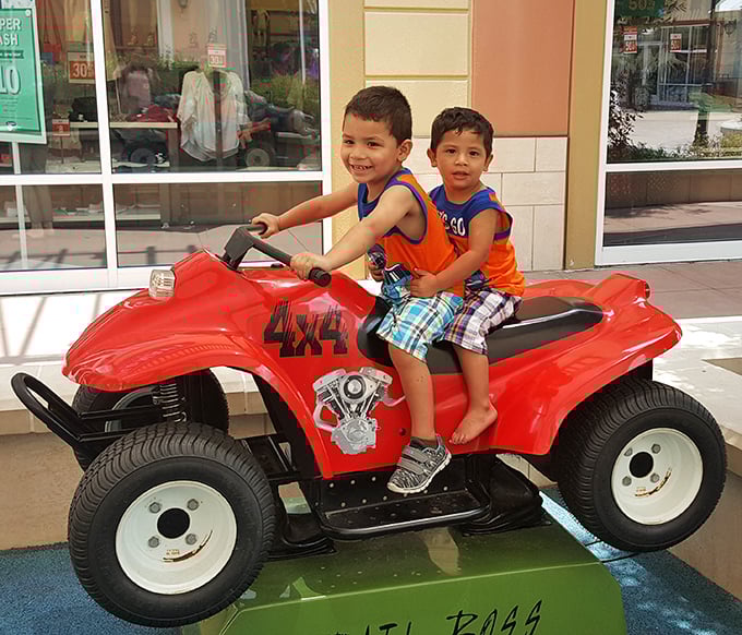 Future shopping champions test drive a miniature ATV. Their expressions say it all: "Mom, this is way better than trying on clothes!"