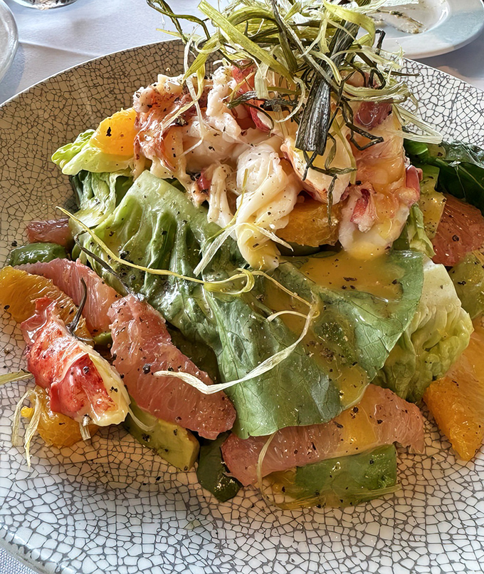 A salad that's having an identity crisis in the best possible way. Part seafood treasure, part citrus celebration, all deliciousness on a designer plate.