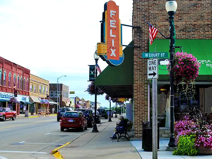 Flower baskets cascade from vintage lampposts while the iconic Flix theater sign reminds us that small-town entertainment never goes out of style.