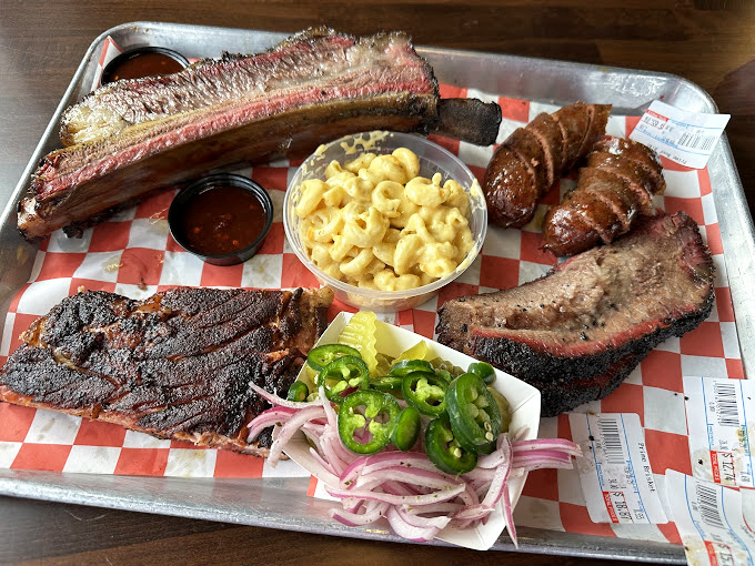 The BBQ sampler platter&mdash;where decision anxiety meets its match because you can have it all, from ribs to brisket to sausage.