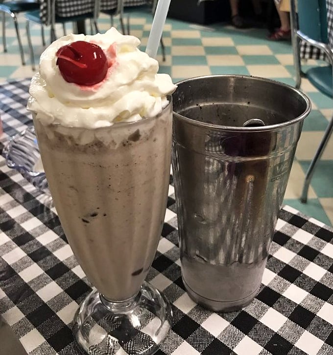 The milkshake arrives with its own sidekick&mdash;that metal mixing cup holding the "bonus round" is the diner equivalent of finding an extra fry at the bottom of the bag.