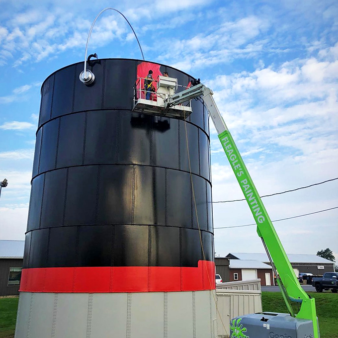 "Honey, I'm going to need a bigger brush." Workers apply fresh graphics to keep this roadside giant looking its colorful best.