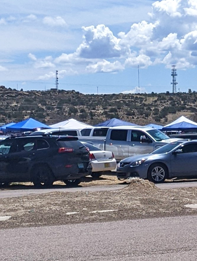The parking lot itself tells a story: a mix of dusty trucks, family sedans, and tourist vehicles converging for this weekly ritual.