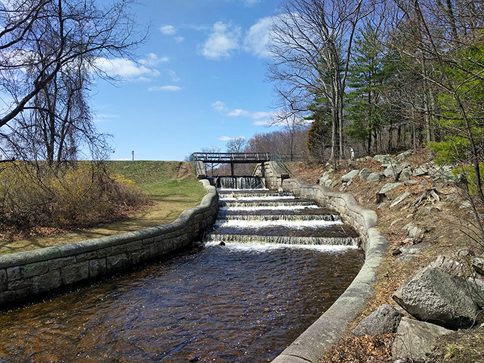 The historic spillway cascades like a miniature Niagara, a testament to the engineering that transformed this valley into a recreational haven.