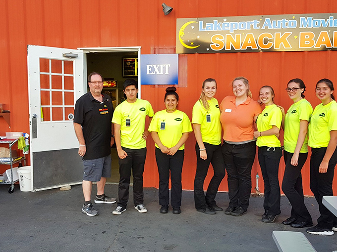 The unsung heroes of movie night stand ready in their bright yellow shirts, preparing to serve up the essential ingredients of drive-in happiness.