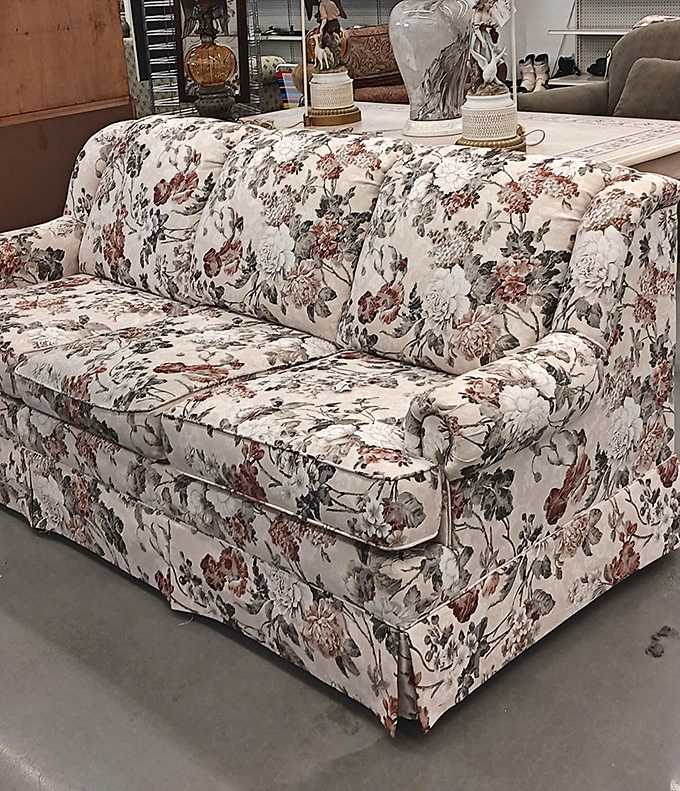 A floral sofa that screams "Golden Girls guest room" in the most delightfully nostalgic way possible.