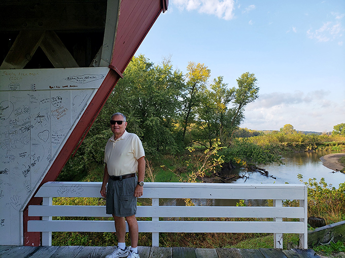 Moments of quiet contemplation await at the bridge's edge, where the rushing water below has witnessed over a century of Iowa's changing seasons.
