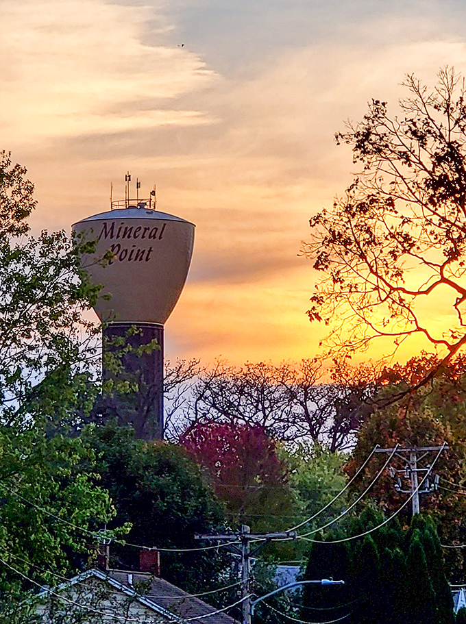 The water tower stands sentinel at sunset, a modern guardian watching over a town that has carefully preserved its 19th-century soul.