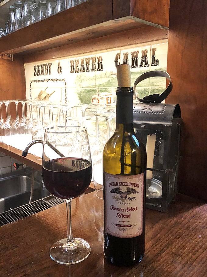 The tavern's own wine label sits beside a generous pour – proof that this place takes every detail seriously.