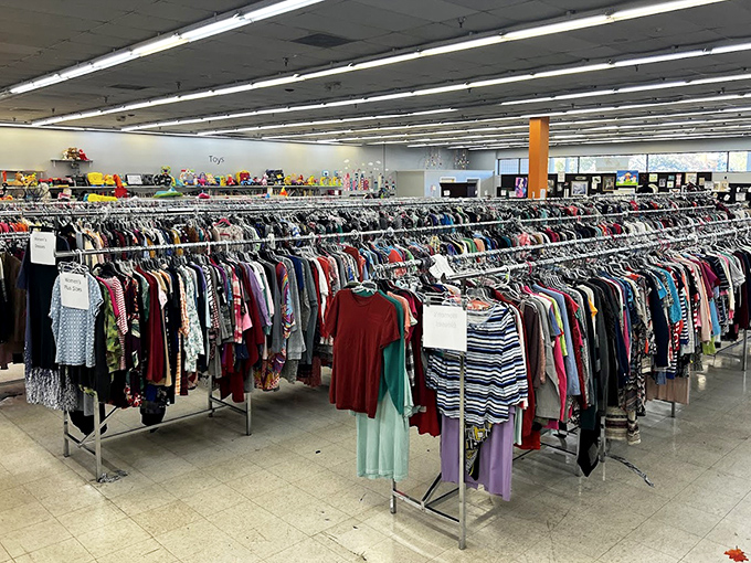 The women's clothing section stretches into infinity, a textile galaxy where fashion trends of decades past orbit alongside contemporary styles.