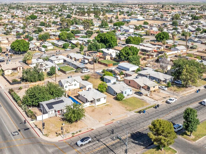 Aerial view of Blythe, California showing modest homes with spacious yards, scattered trees, and the desert community's grid layout.