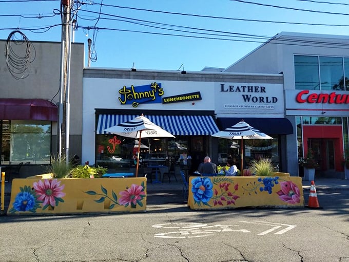 Johnny's Luncheonette's colorful barriers and blue-striped awning create a cheerful urban oasis where comfort food meets sidewalk charm.