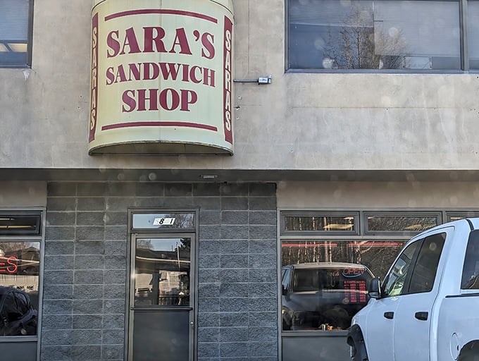 Sara's iconic yellow sandwich sign stands tall against the Anchorage skyline &ndash; a beacon for the seriously sandwich-obsessed.