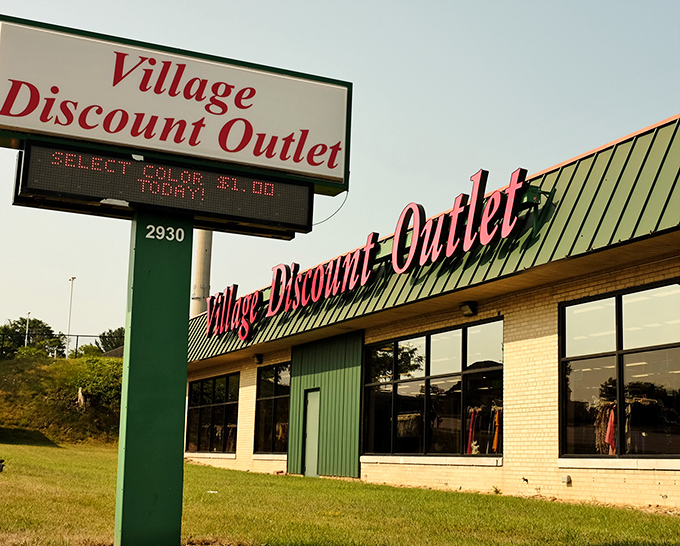 Village Discount's sign and digital board announce: "Attention bargain shoppers: your paradise awaits!" The green roof is just a bonus.