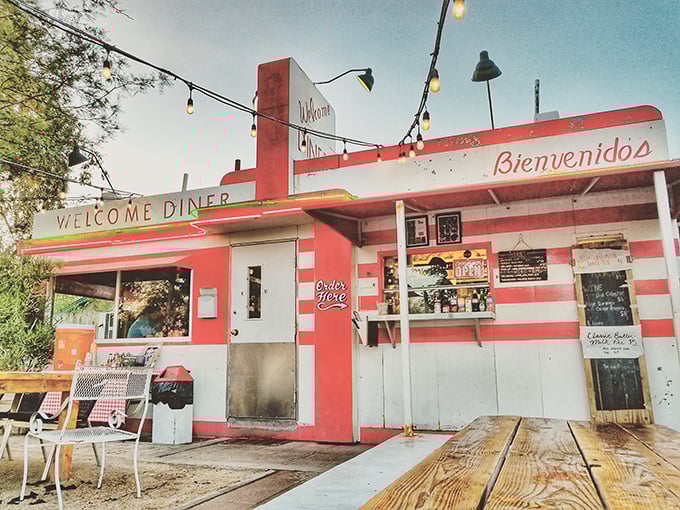 Those candy-striped walls and string lights say "fiesta meets comfort food" at Welcome Diner's charming outdoor setup.