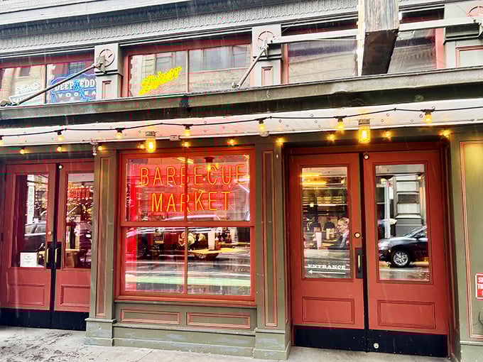 Rain can't dampen smoked meat enthusiasm! Hill Country's glowing red sign cuts through city gloom, promising warm, wood-scented embraces and brisket that makes troubles melt away.