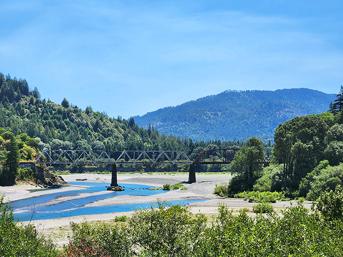 Crystal-clear river meets mountain backdrop where summer days invite families to splash and play together.