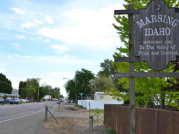 Marsing welcomes visitors with its iconic wooden sign, proudly announcing itself as "The Valley of Fruit and Harvest" under Idaho's blue skies.