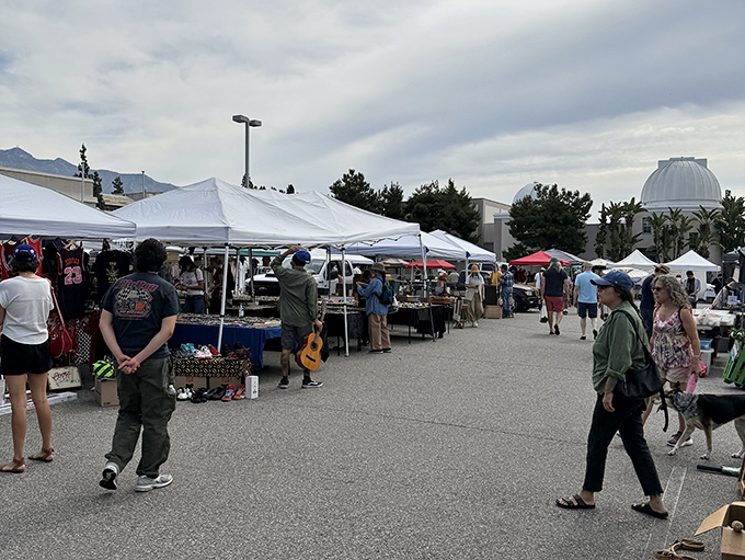 White tents against Pasadena's blue skies at PCC Flea Market, where shopping supports student scholarships. Guilt-free treasure hunting!