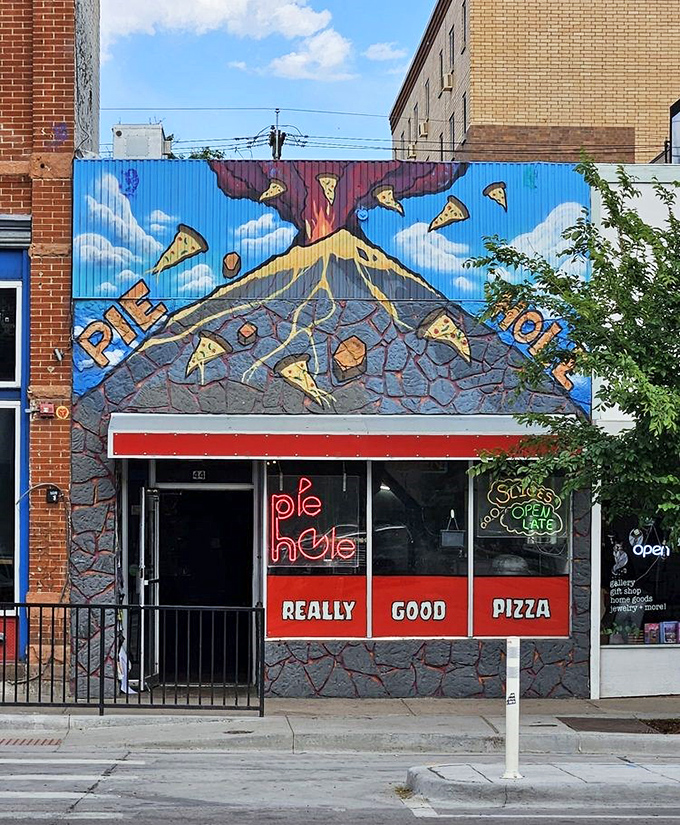 The vibrant, erupting pizza mural at Pie Hole promises an explosion of flavor. Those flying pizza slices are practically a street art prophecy.