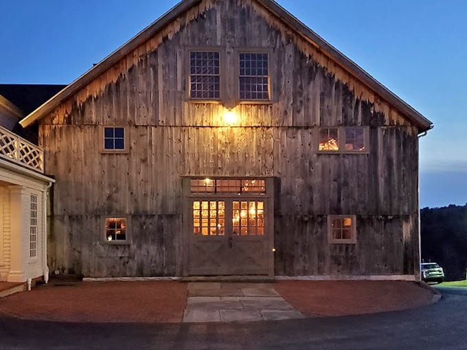 As dusk falls, Salem Cross Inn's weathered barn glows with warmth. Centuries of history seasoning every steak!