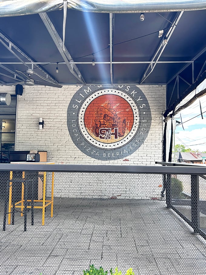 The clean white brick wall at Slim & Husky's serves as canvas for their distinctive logo &ndash; a modern pizza joint with artistic flair.