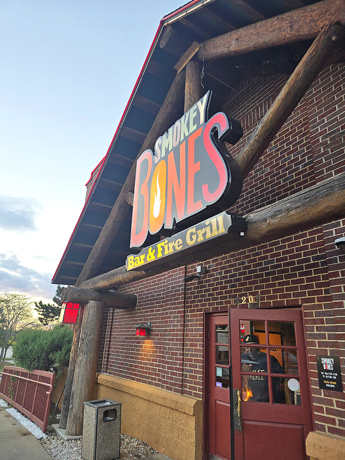 The warm glow of Smokey Bones' sign against the evening sky promises comfort food that hugs your soul. Those wooden beams aren't just decoration&mdash;they're a promise.