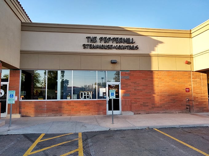 Evening transforms The Peppermill's simple exterior into an inviting glow of promise. Cocktails and steaks await inside!