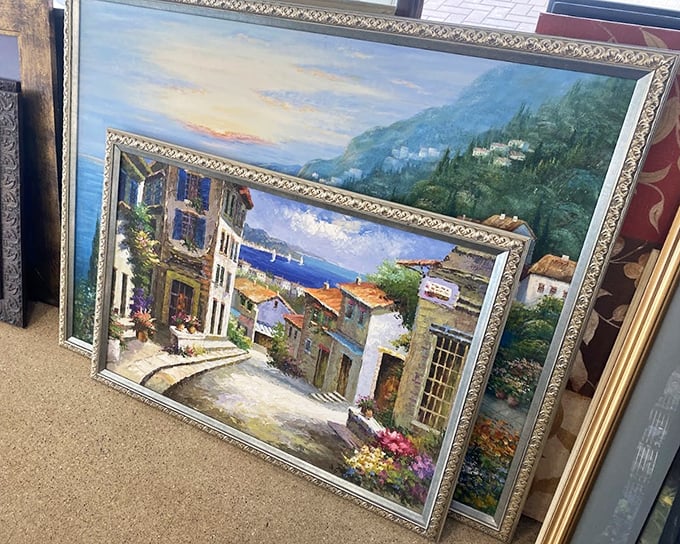 Someone's Mediterranean vacation dreams now await adoption in the art section. These framed coastal scenes once matched someone's living room perfectly.