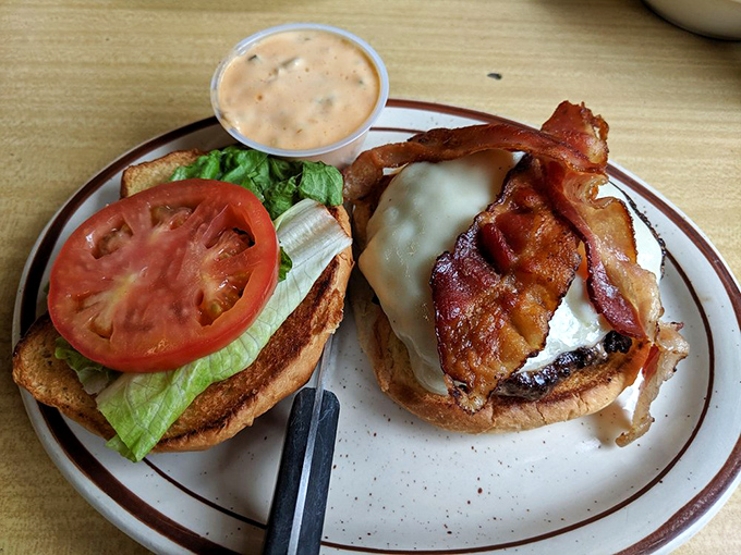 This isn't just a burger&mdash;it's comfort on a plate. Melted cheese cascades over bacon while fresh vegetables stand ready to ease your conscience.