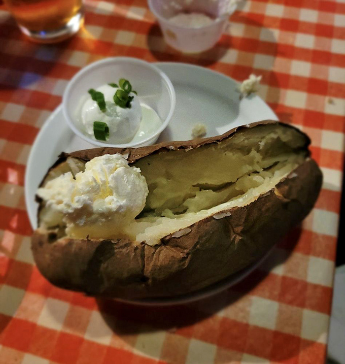 This isn't just a baked potato – it's a fluffy, starchy canvas awaiting your artistic touch of sour cream, butter, and green onion.