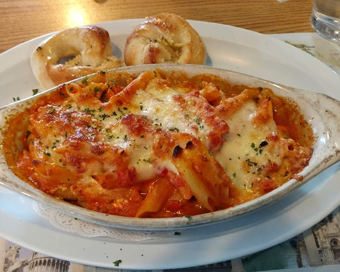 Baked ziti that's achieved the perfect sauce-to-cheese ratio, accompanied by garlic rolls that could make a vampire reconsider their lifestyle choices.