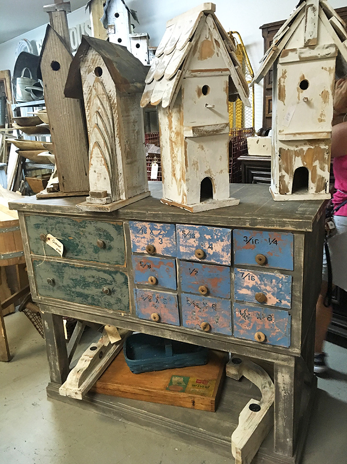 Rustic birdhouses perched atop a weathered multi-drawer cabinet &ndash; architectural miniatures that would make any garden wren feel like royalty.