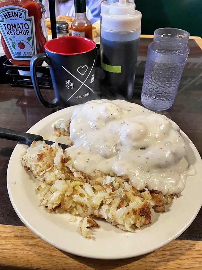 Country gravy cascading over hash browns like a peppery waterfall. This is what breakfast dreams are made of, folks.