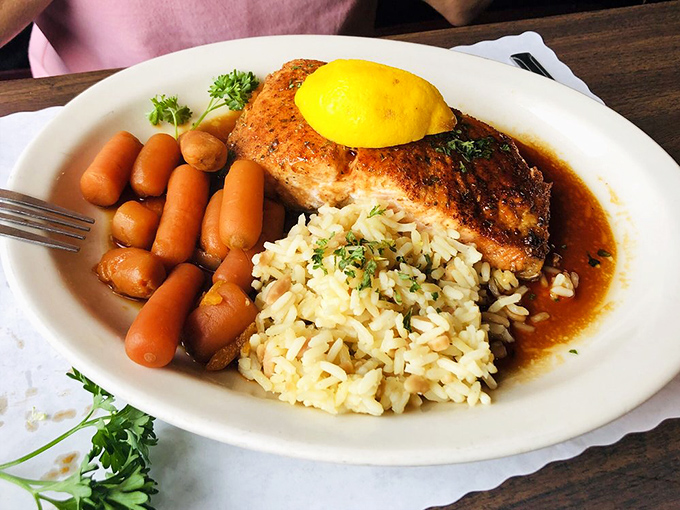 Bourbon-glazed salmon that's traveled upstream and upgraded its wardrobe, now lounging on a bed of rice with carrot companions.