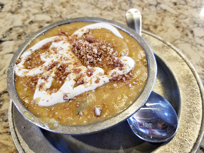 Butternut squash bisque topped with whipped cream and what looks like toffee bits is autumn in a bowl.