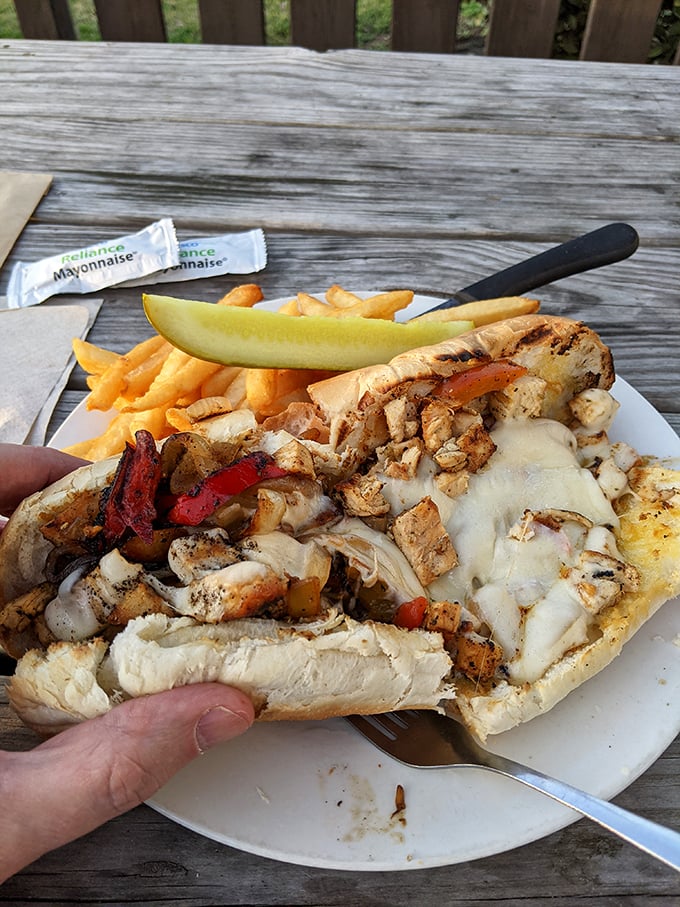 The chicken Philly – where barbecue joint meets cheesesteak paradise, creating a sandwich that demands to be eaten outdoors on a wooden deck.