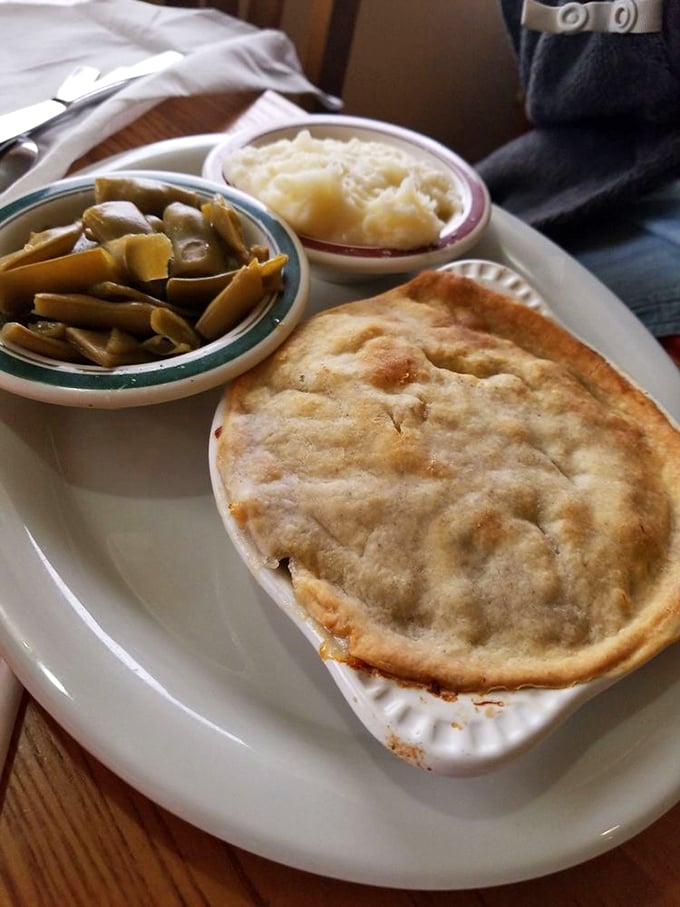 This chicken pot pie isn't messing around&mdash;a golden dome of pastry protecting a treasure of comfort food beneath, flanked by green beans and mashed potatoes.