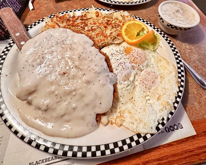 Chicken fried steak swimming in country gravy &ndash; the kind of breakfast that requires both a knife and a nap afterward.