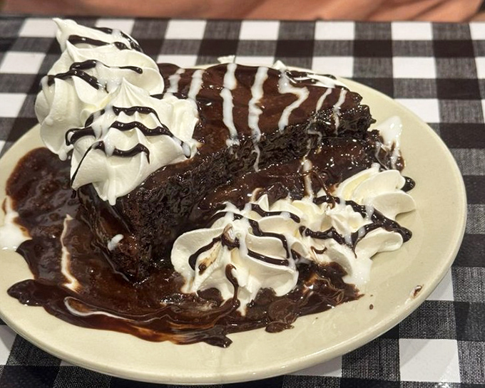 Chocolate cake drizzled with enough fudge sauce to make your dentist schedule an intervention but your taste buds throw a parade.