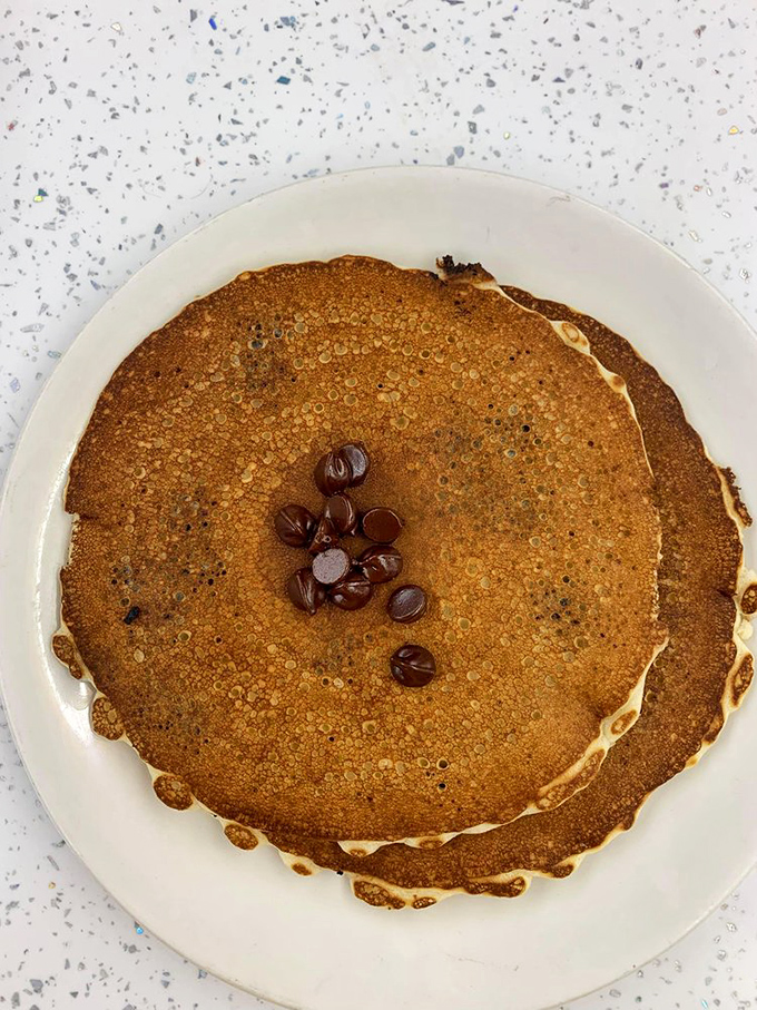 This pancake isn't just large&mdash;it's the size of your childhood dreams, with chocolate chips playing hide and seek across its golden landscape.