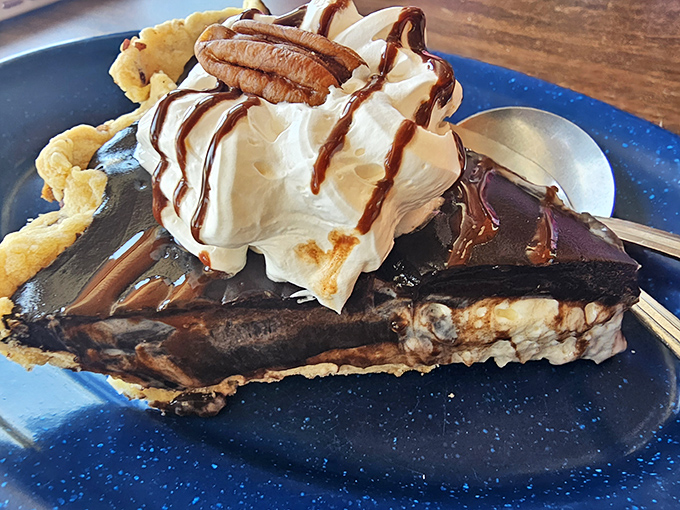 A slice of chocolate cream pie that's dressed for success with whipped cream, chocolate drizzle, and a pecan crown. Sweet dreams are made of this.