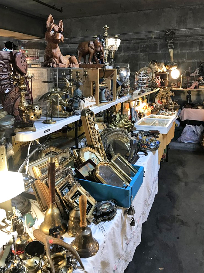 A treasure hunter's dream table, where brass figurines and vintage frames create a museum of curiosities that would make Wes Anderson swoon.