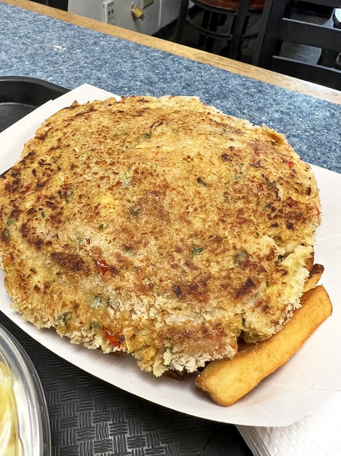 This crab cake is the size of a small frisbee, golden-brown and ready to make your usual seafood joint's version look like an appetizer. 