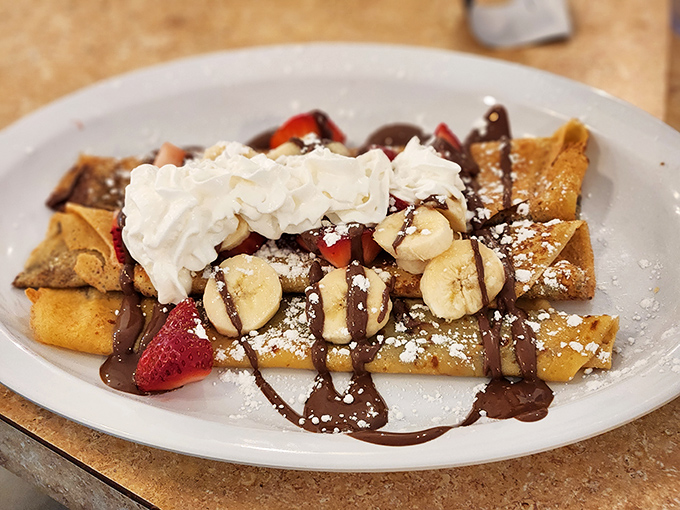 These crepes have dressed for dessert, draped in chocolate, crowned with fresh fruit, and dusted with powdered sugar like fresh Indiana snow.