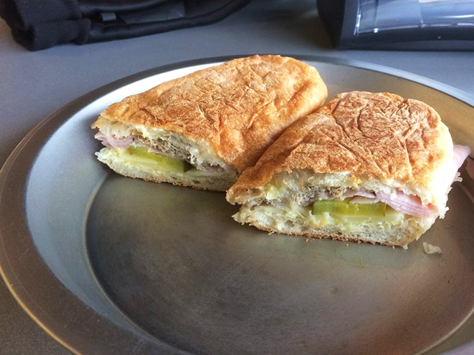 The Cuban sandwich, sliced to reveal its inner architecture of ham, pickles and melted cheese – a handheld masterpiece.