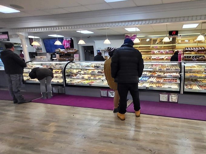 The display cases stretch like a museum of edible art, where patrons contemplate their choices with the seriousness of art collectors.