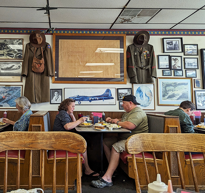 Military uniforms and aviation memorabilia create the perfect backdrop for diners enjoying the timeless ritual of a shared breakfast.